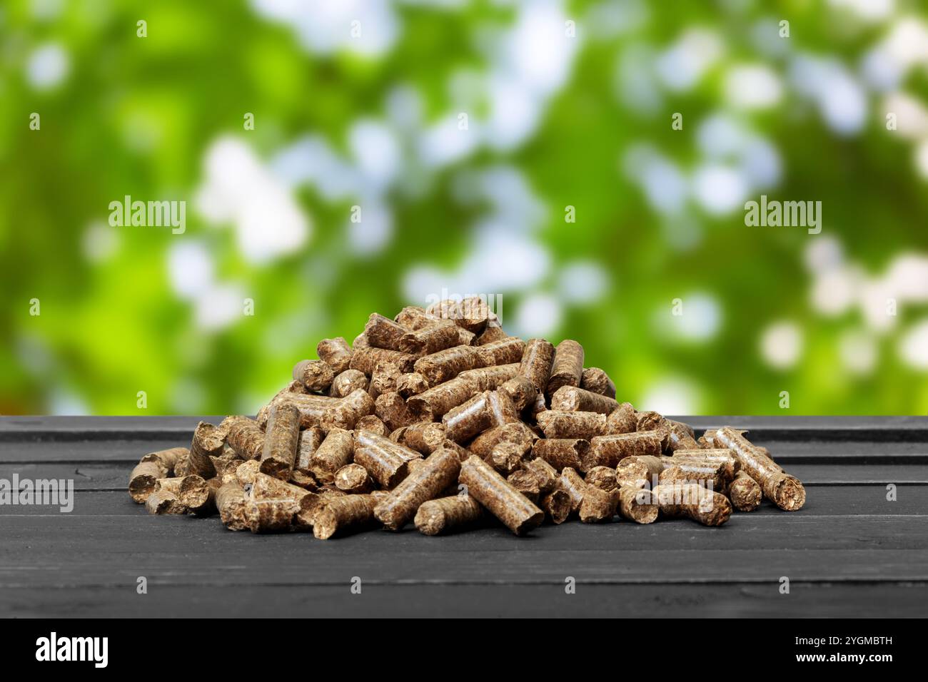 Wood pellets on a green background. Biofuels Stock Photo - Alamy