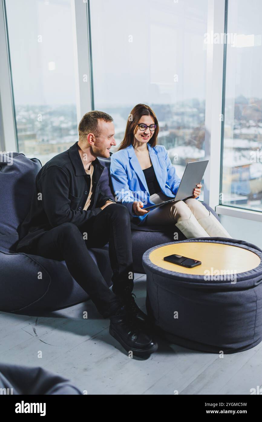 Two business people working remotely online using a laptop. Colleagues ...
