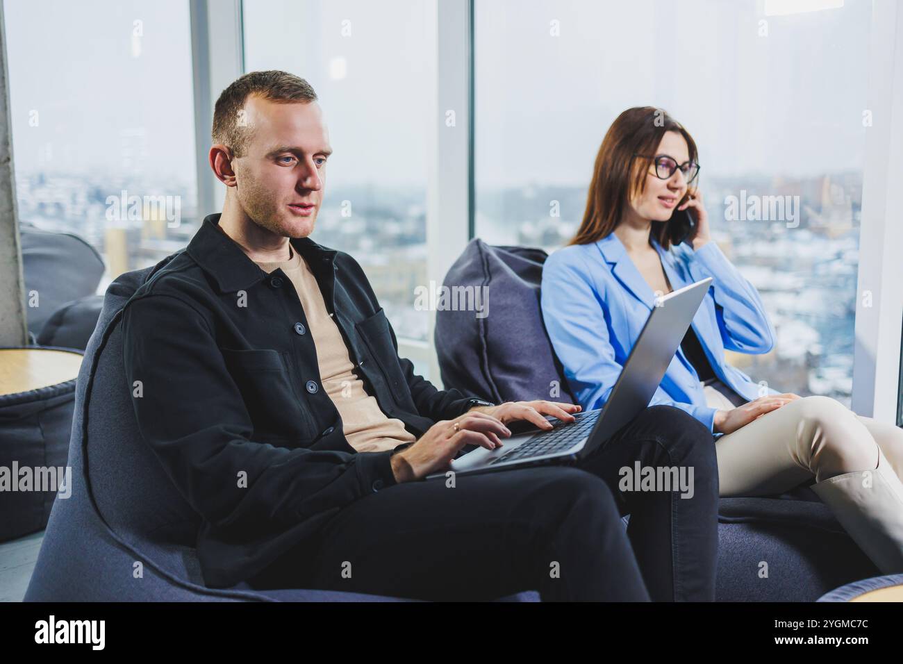 Two business people working remotely online using a laptop. Colleagues ...