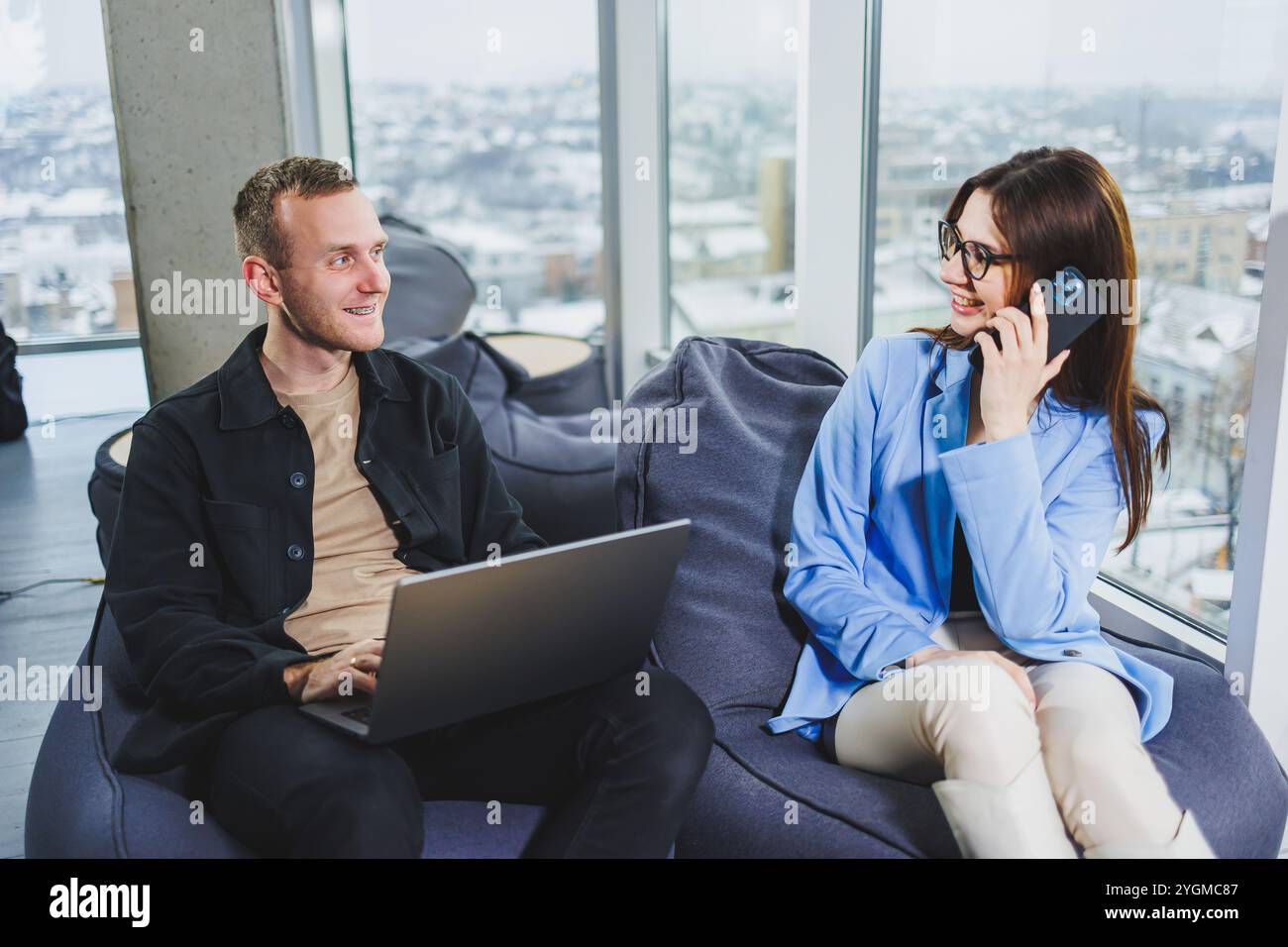 Two business people working remotely online using a laptop. Colleagues ...