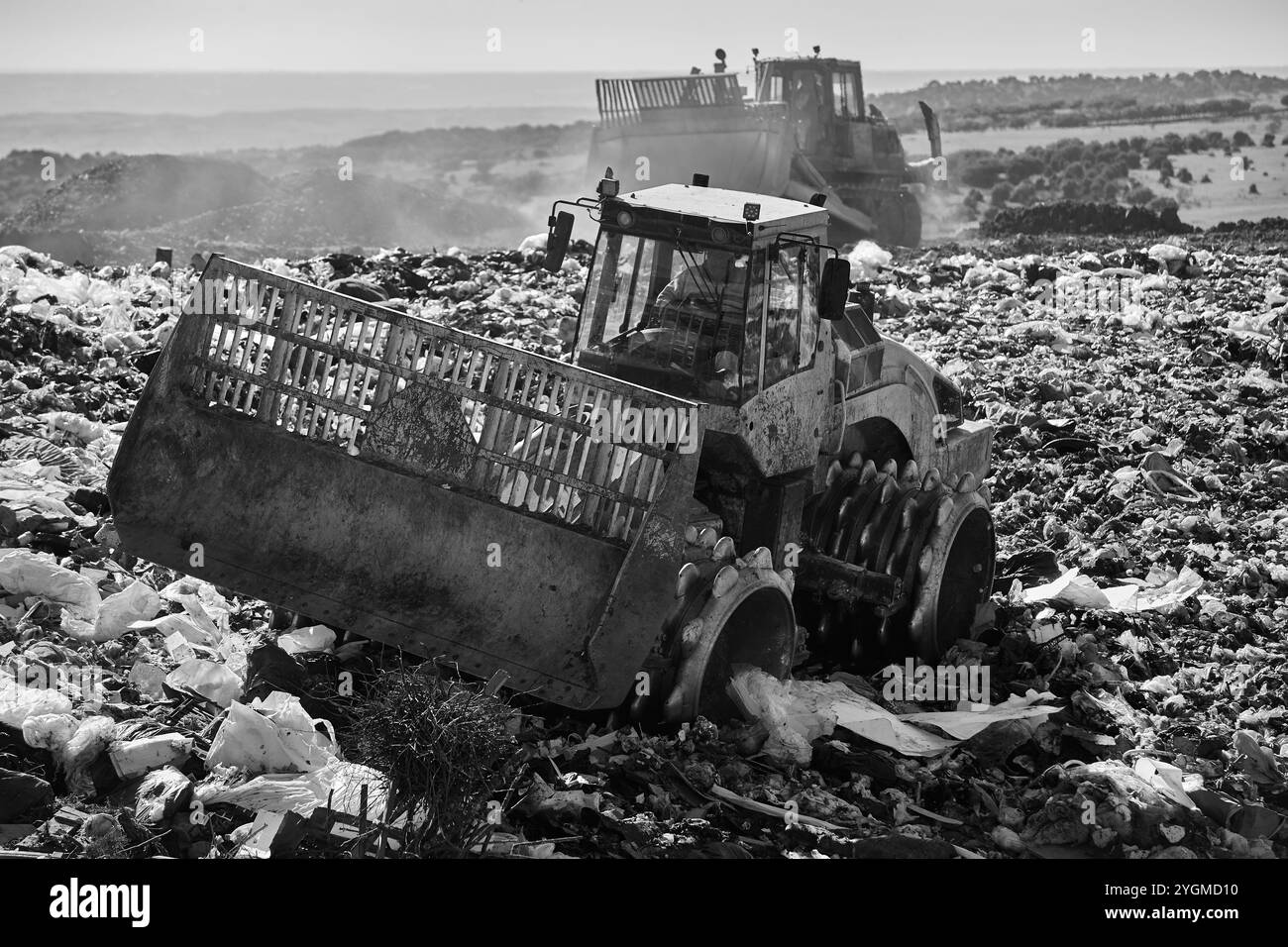 Heavy machinery shredding garbage in an open air landfill. Waste Stock ...