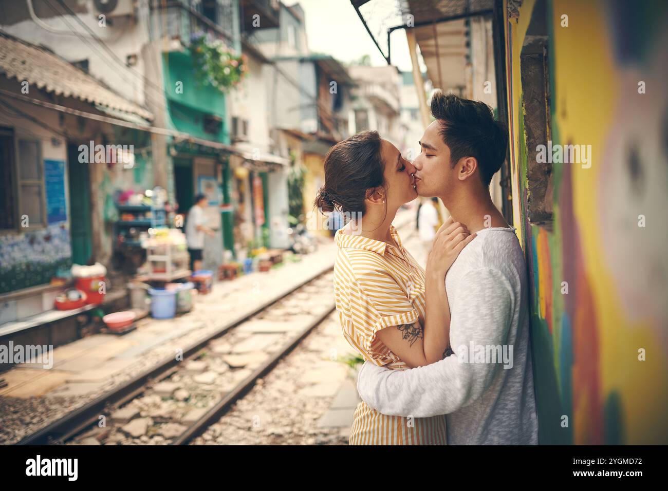 Couple, kiss and travel by train station in city for romance, affection or love on vacation ...