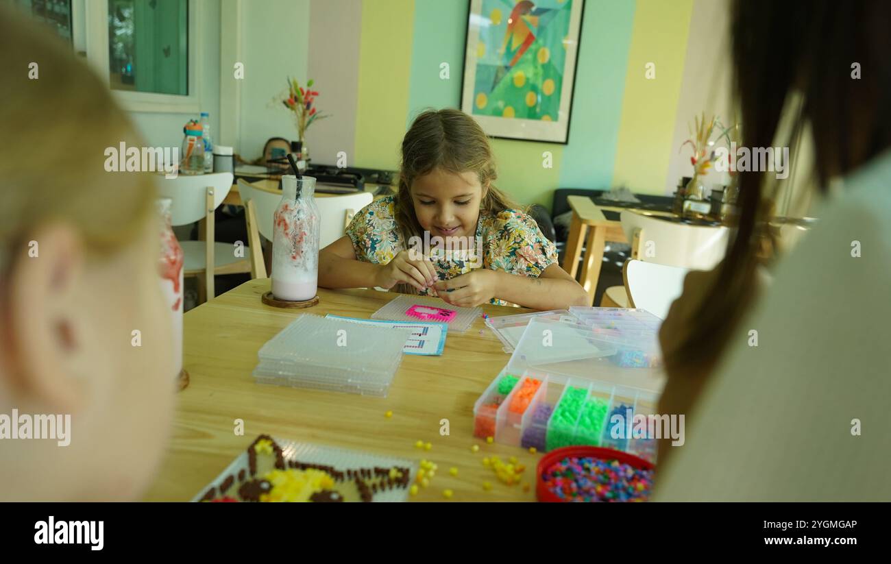 Teacher in workshop teched two girls how to assemble a thermo mosaic ...