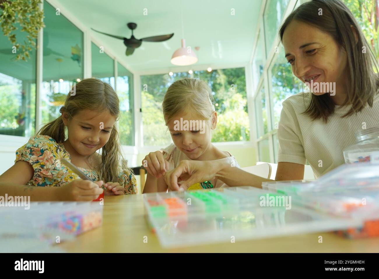 Teacher in workshop teched two girls how to assemble a thermo mosaic ...