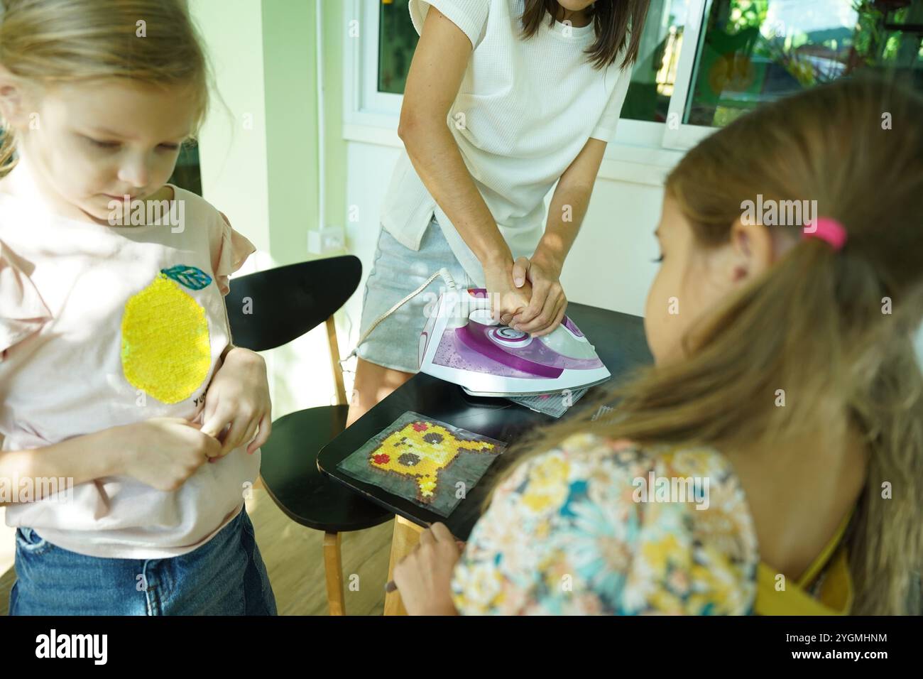 Teacher in workshop teched two girls how to assemble a thermo mosaic ...