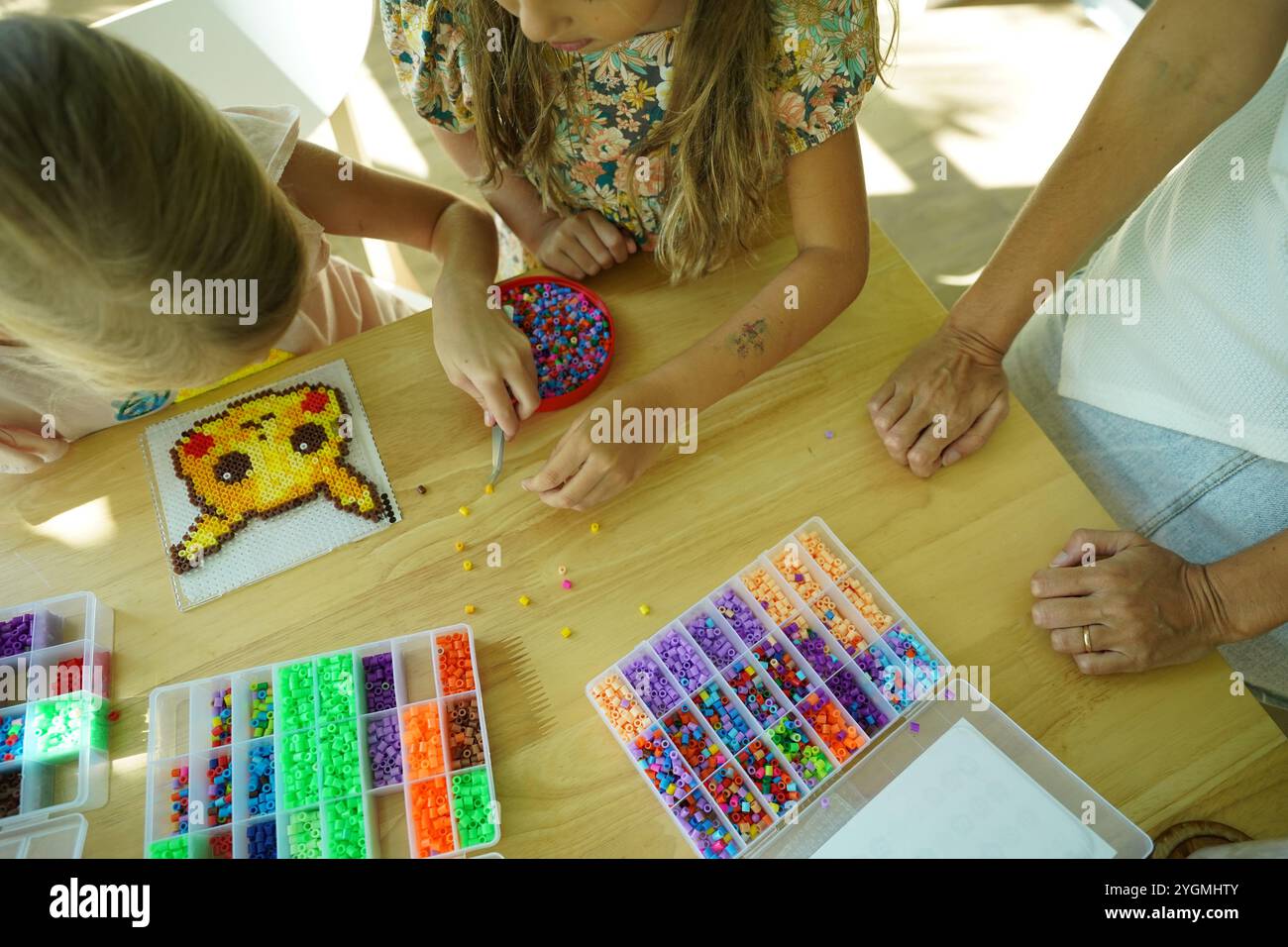 Teacher in workshop teched two girls how to assemble a thermo mosaic ...