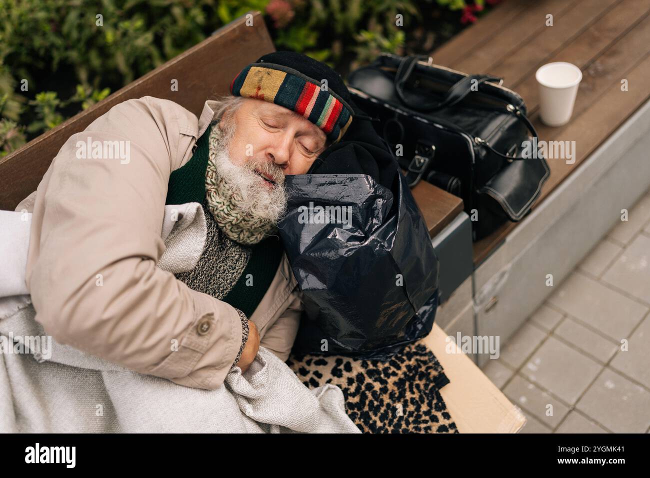 Top view of tired aged homeless man sleeping lying with closed eyes on ...