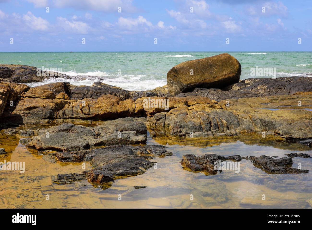Empty tropical beach with big stones, view to yellow sand and blue sea ...