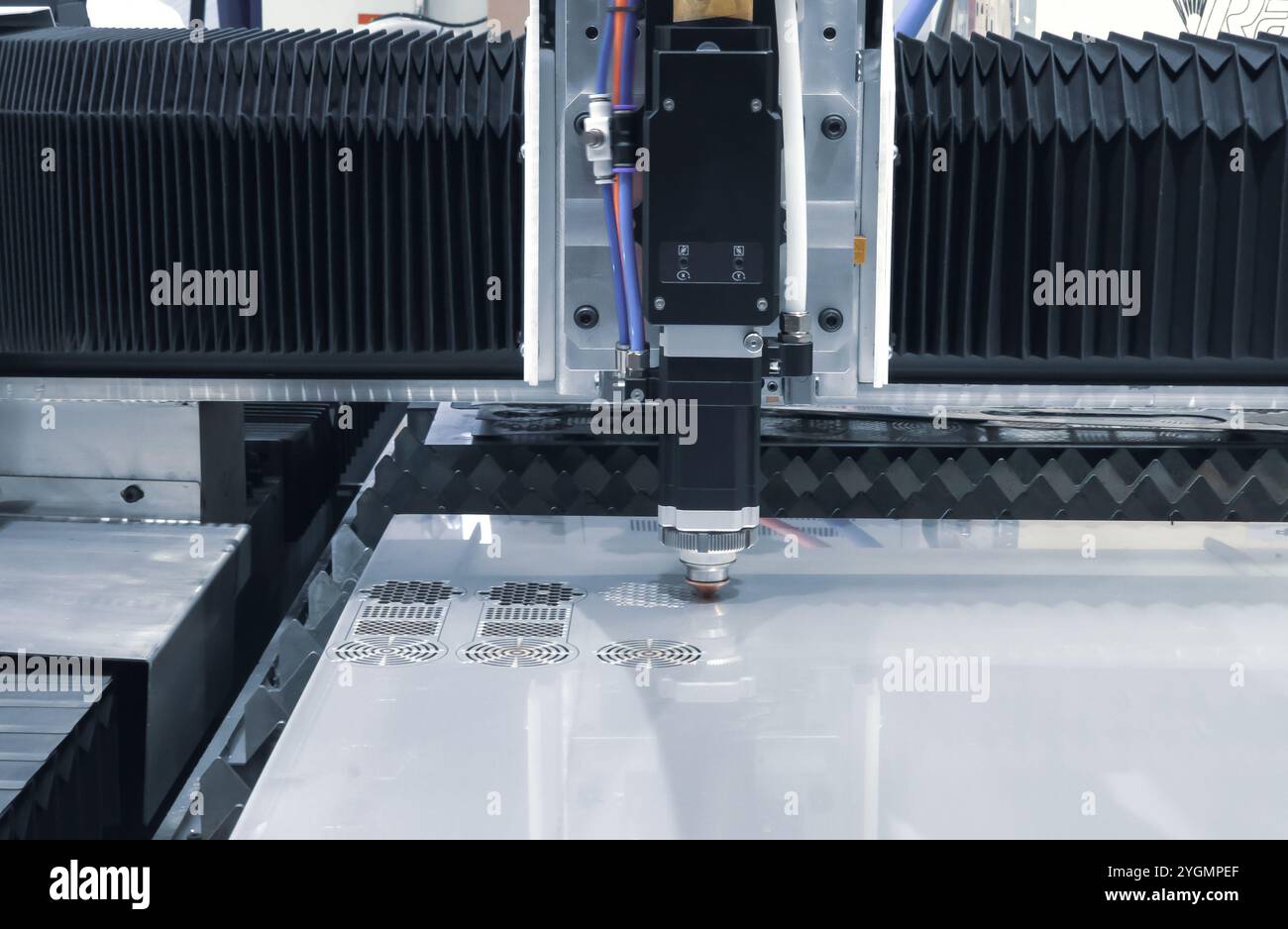 CNC fiber laser cutting machine cutting metal sheet with flying sparks ...