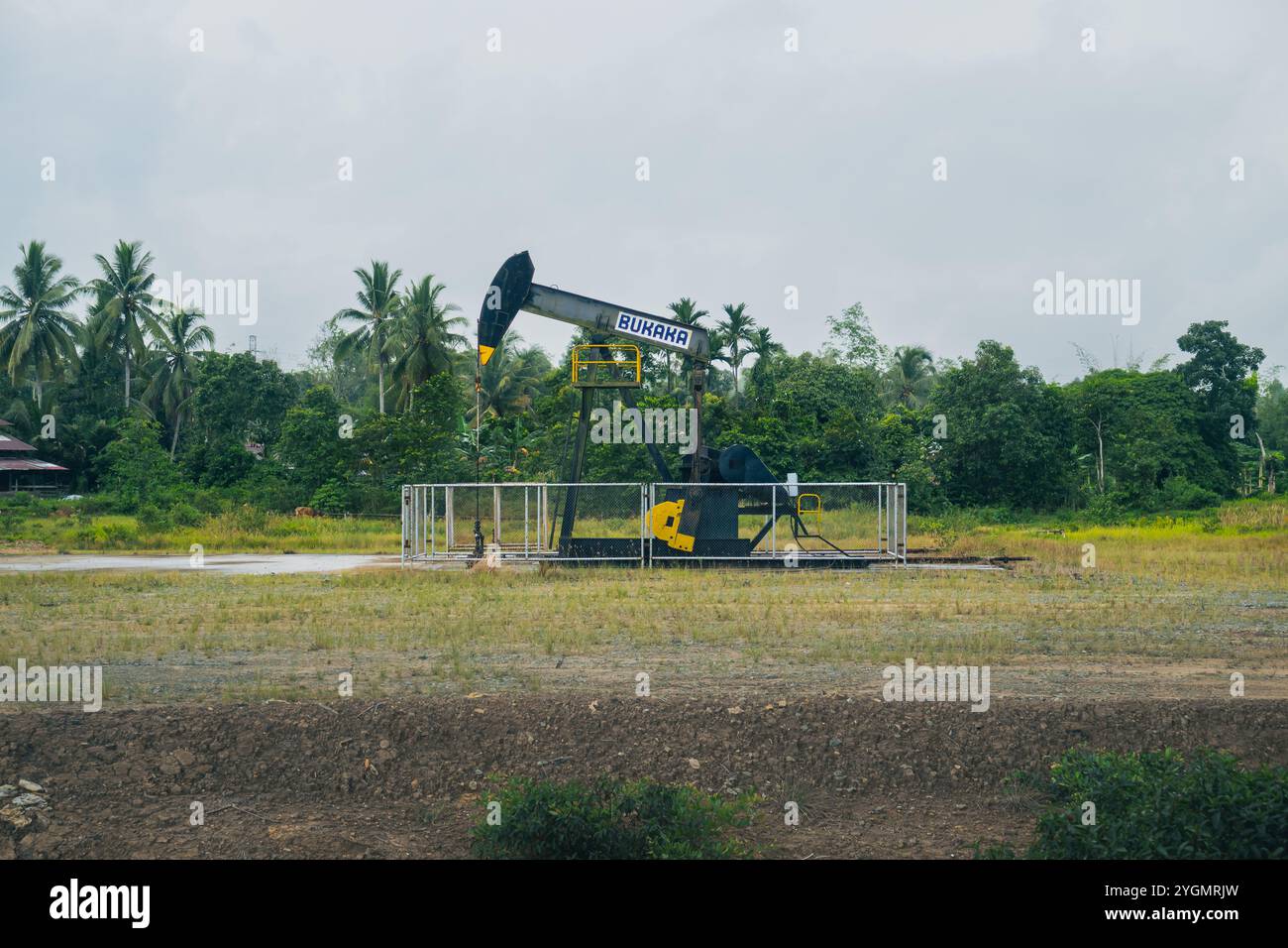 old well with pumpjack or lever pump owned by Pertamina in the Samboja ...