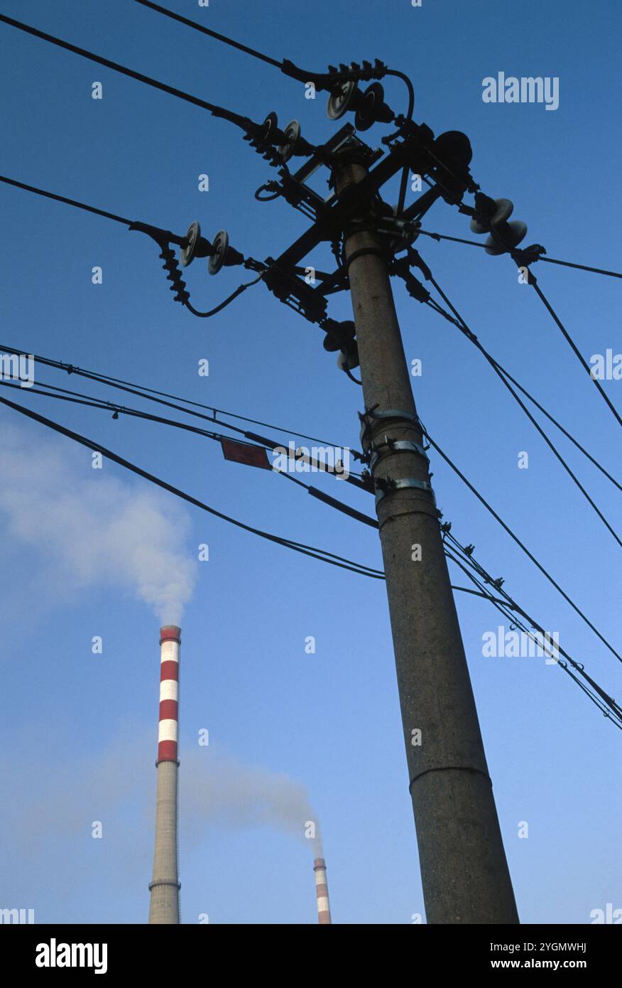 An electricity pole frames the smoke stacks of a coal power plant in ...