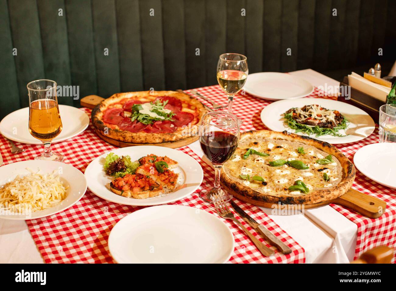 Italian Restaurant Table Spread with Various Pizzas, Pasta Dishes, and ...