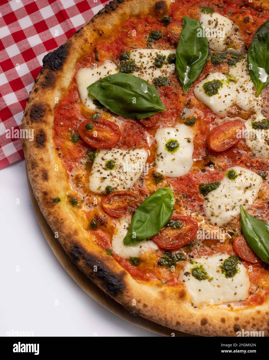 traditional Margherita pizza topped with fresh mozzarella, basil leaves, and a rich tomato sauce ...