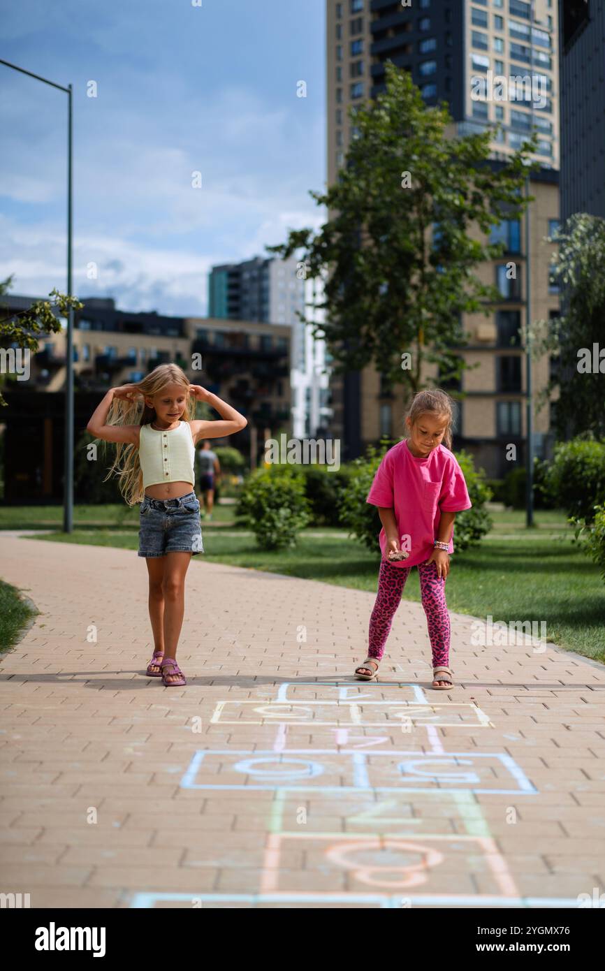 Girls playing hopscotch in the yard in the summer Stock Photo - Alamy