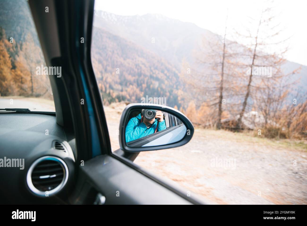 Photographer captures reflection in car mirror during mountain drive ...