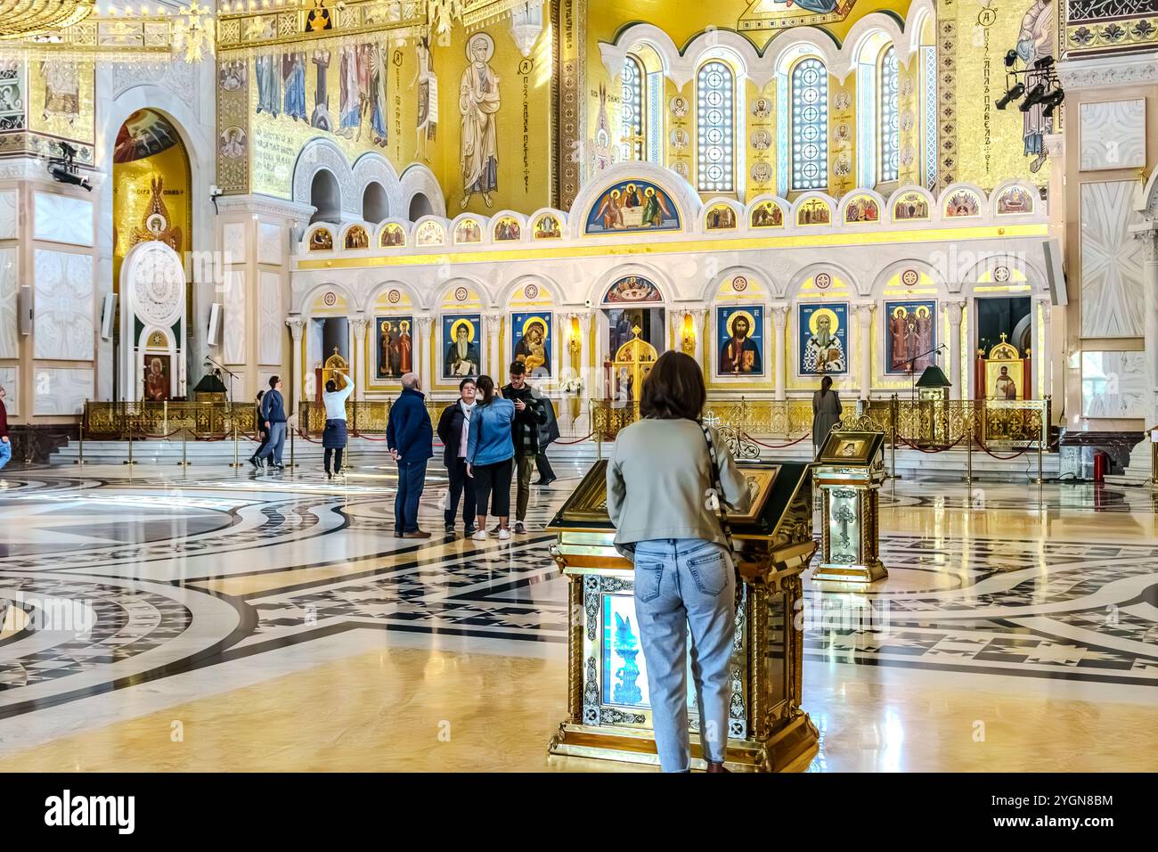 people pray in an Orthodox church, frescoes on the ceilings and walls ...