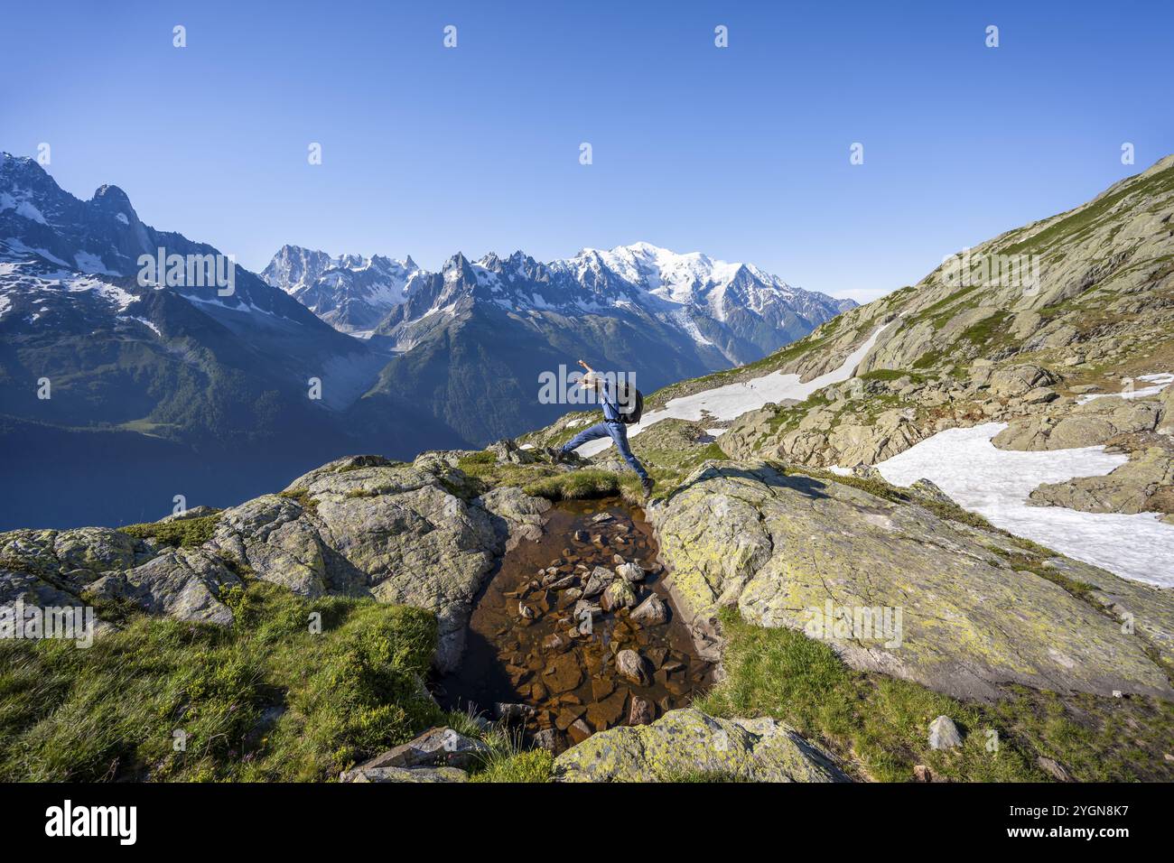 Mountaineer jumping, mountain panorama, view of mountain peaks Grandes ...