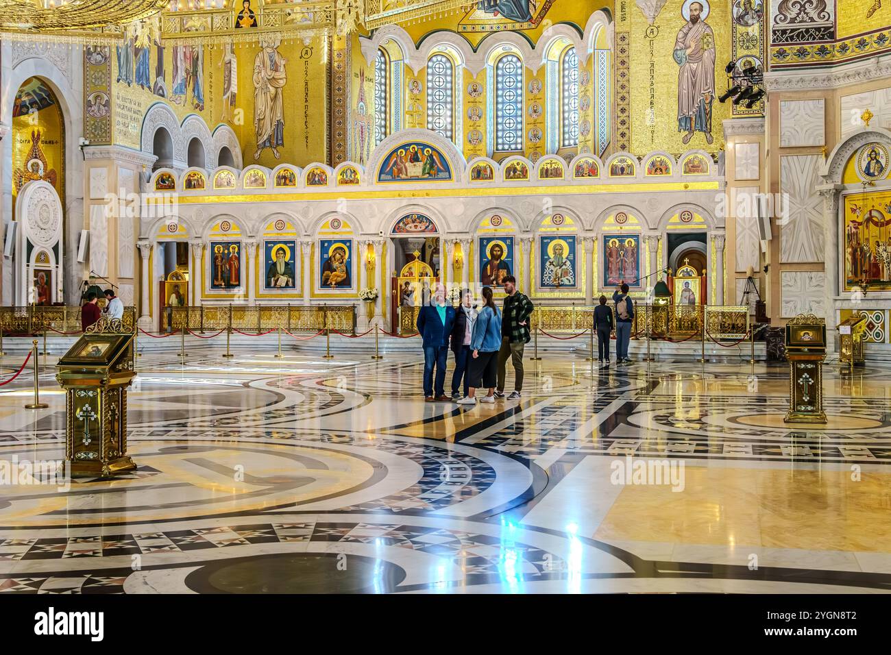 people pray in an Orthodox church, frescoes on the ceilings and walls ...
