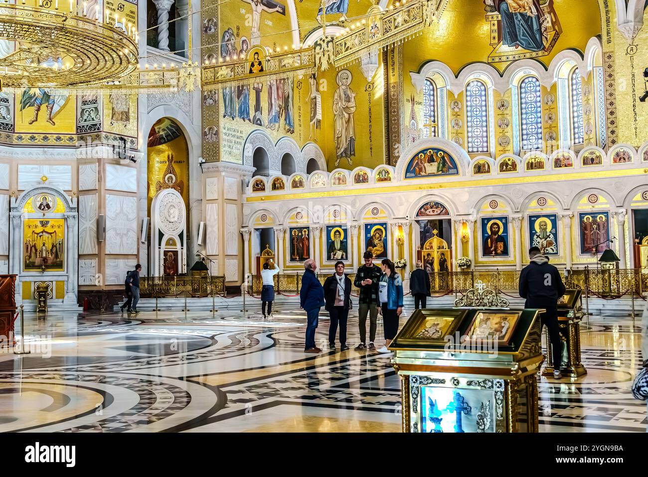 people pray in an Orthodox church, frescoes on the ceilings and walls ...