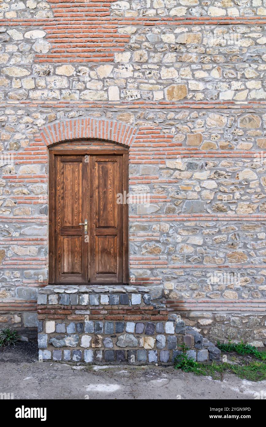 Stone structure features a wooden double door accessible via stone ...