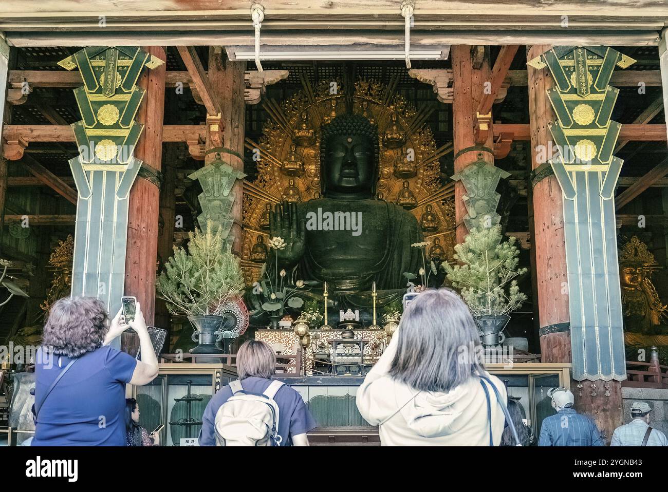 Tourists photograph the bronze statue of the Great Buddha at Todaiji ...