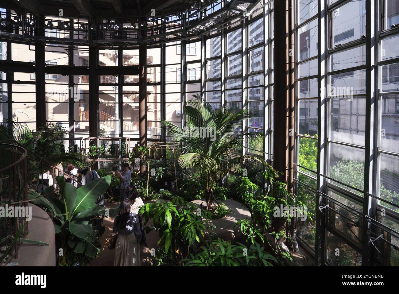People walk through a hall full of plants in the Shibuya Fureai ...
