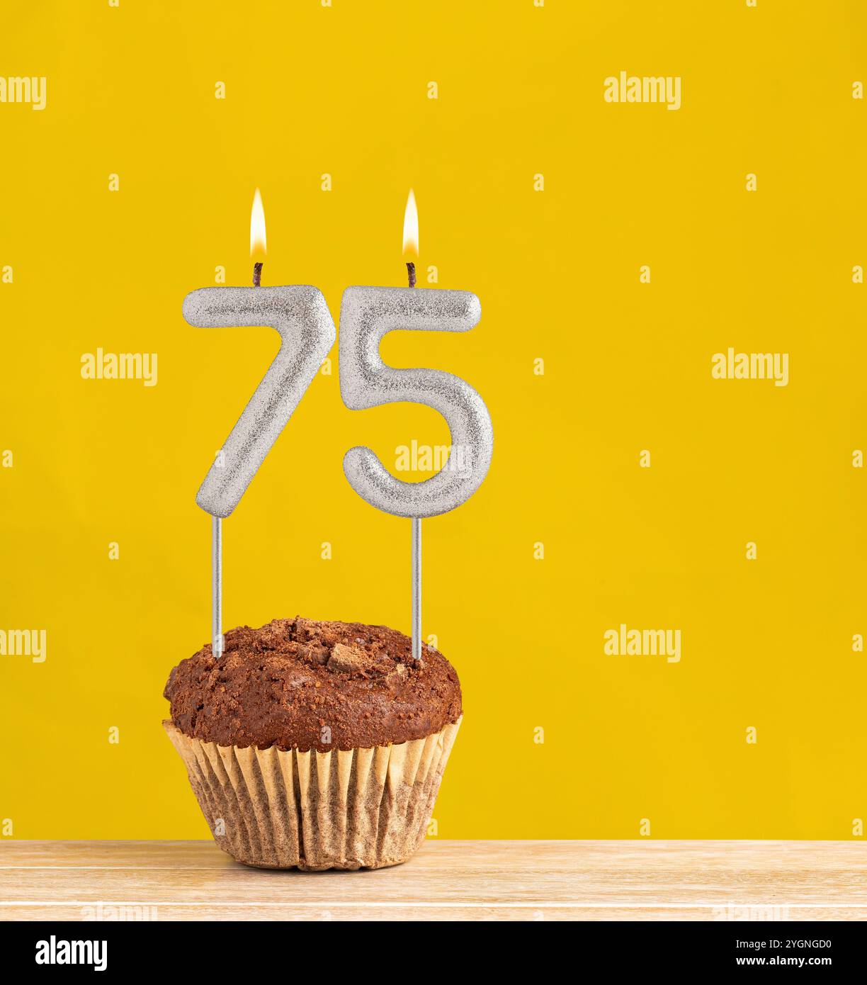 Number 75 birthday candle - Chocolate cupcake on a yellow background ...