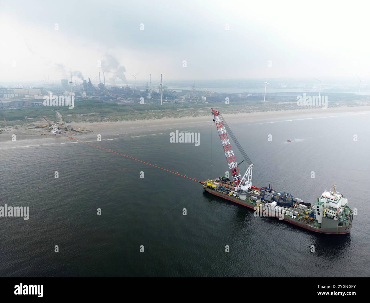 A vessel unrolls a seacable from an offshore windpark to an onshore ...