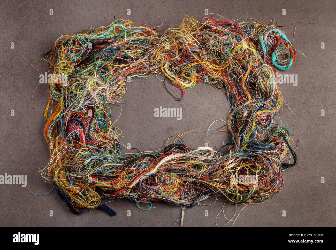 Colorful tangled threads on dark gray background Stock Photo - Alamy