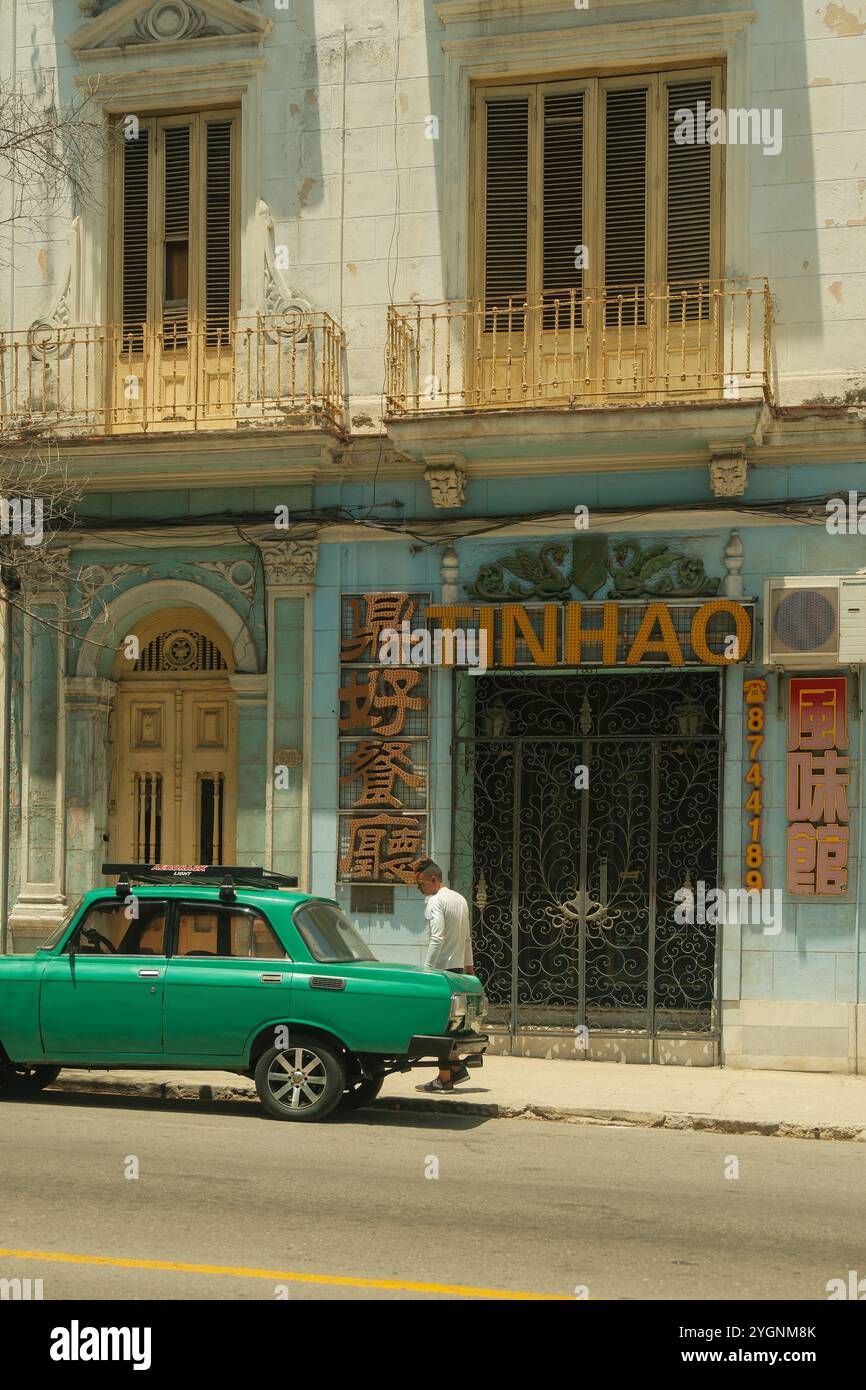 Havana, Cuba 2024 Apr16. Man walking to green Soviet Moskvitch car ...