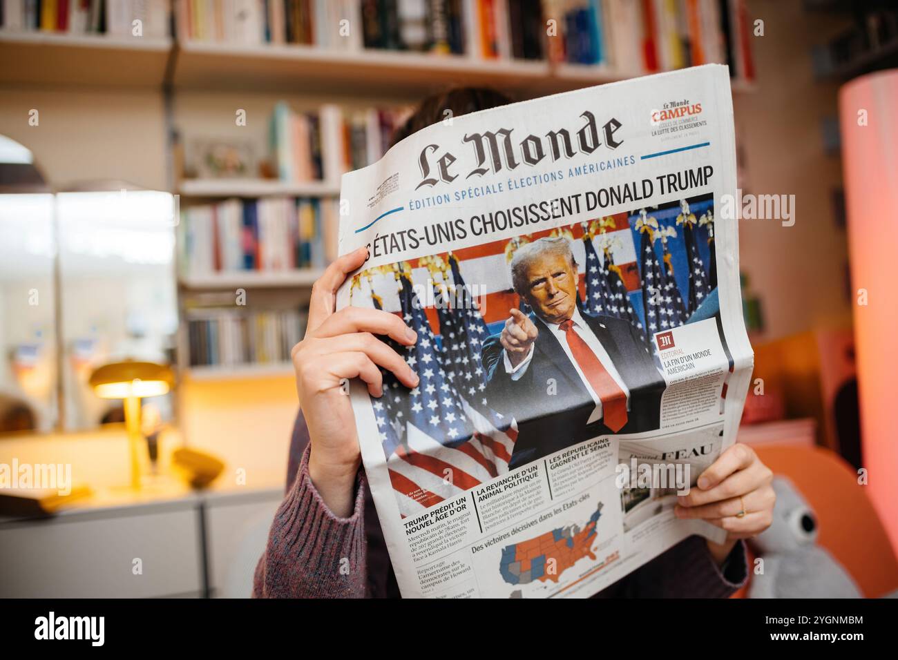 Paris, France - Nov 7, 2024: Person reading French newspaper Le Monde ...