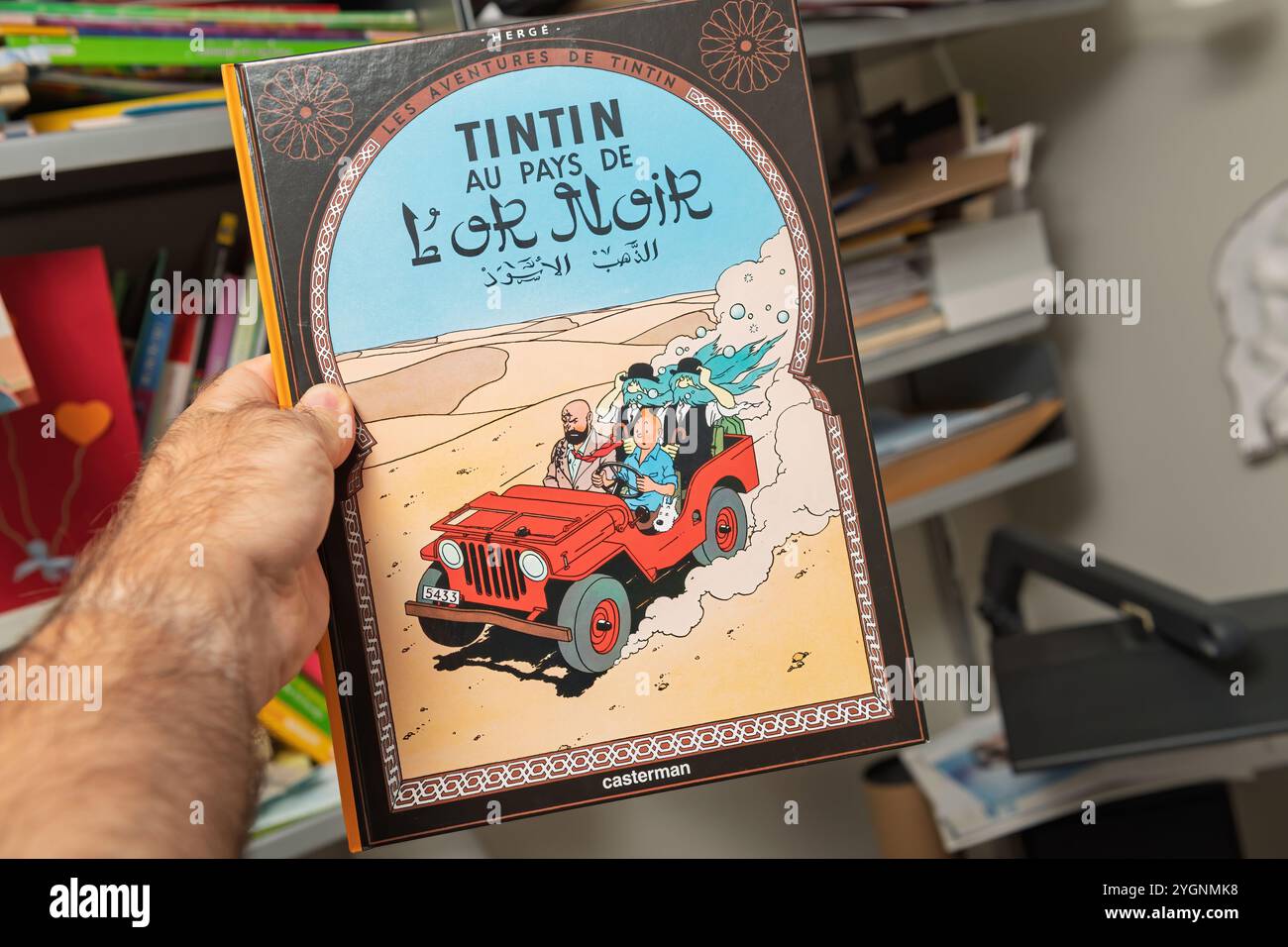 Paris, France - Oct 7, 2024: Hand holding Tintin au Pays de l'Or Noir ...