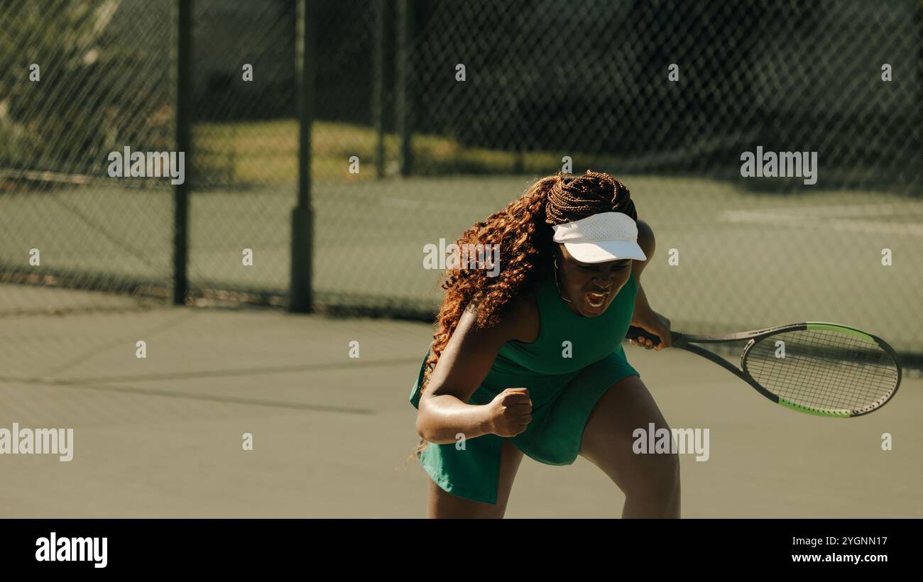 An excited female tennis player celebrating a victory on the court ...