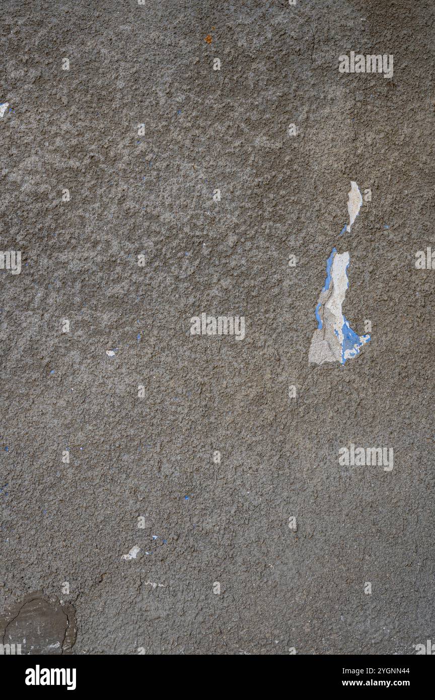 Texture of old and crumbling gray plaster revealing a layer of an even ...