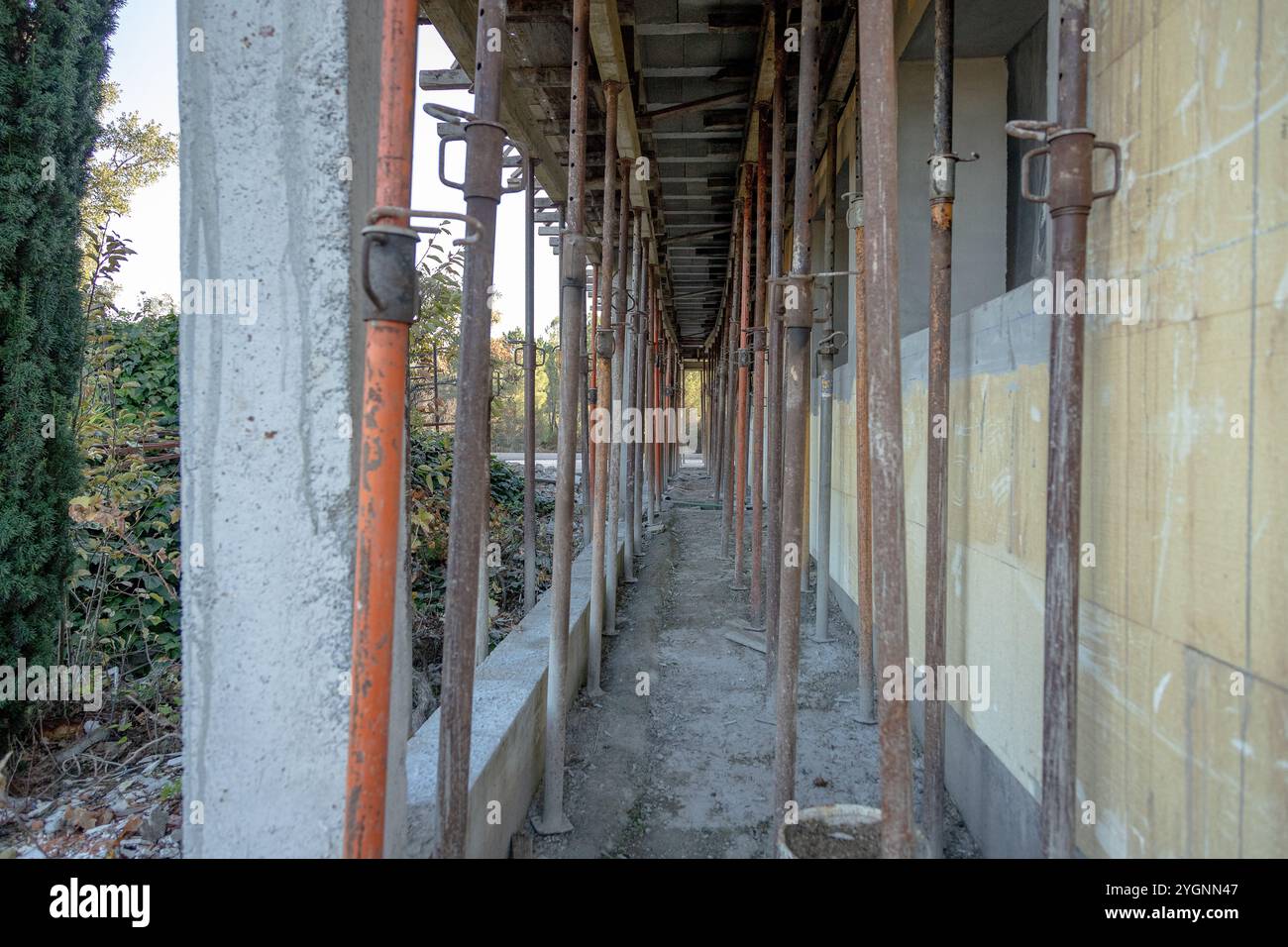 A construction site corridor supported by metal scaffolding, showing ...