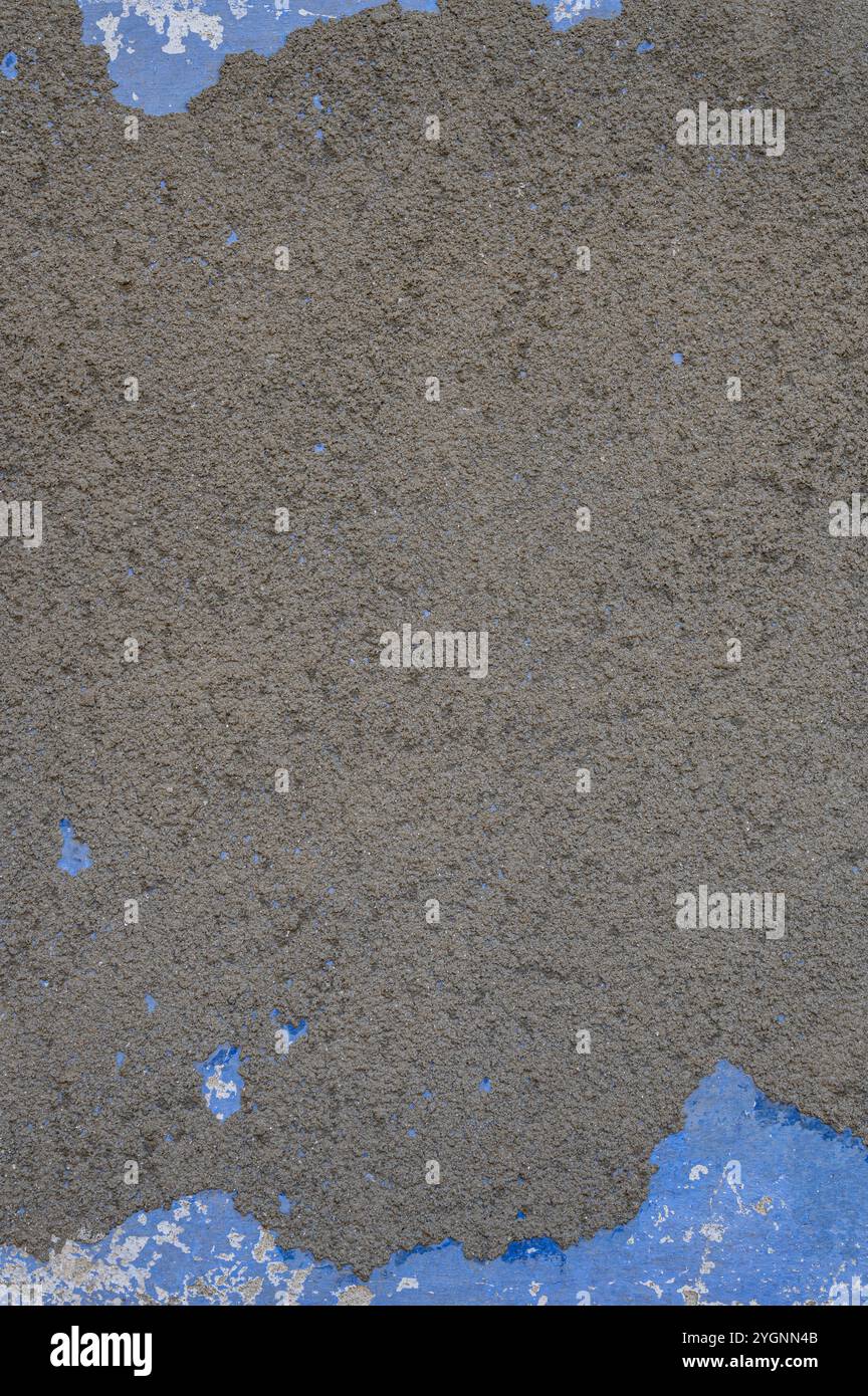 Texture of old and crumbling gray plaster revealing a layer of an even ...
