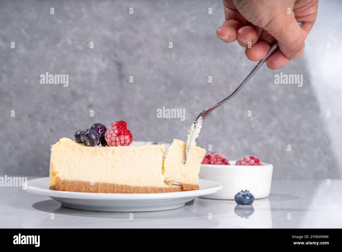 Cheesecake portion slice on plate, with raspberry on blueberry on white ...