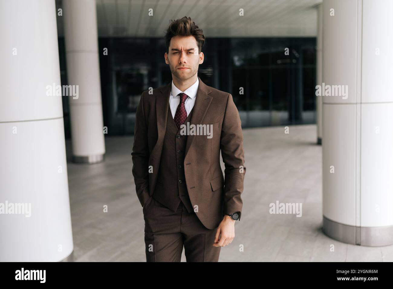 Portrait of confident successful businessman in stylish suit walking ...