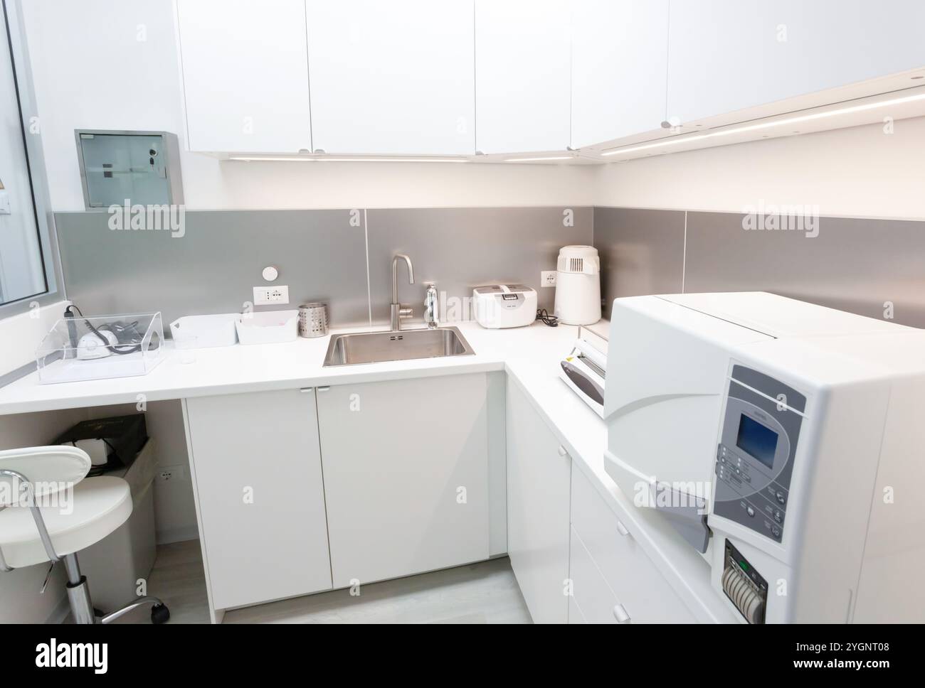 Modern clinic room equipped with sterilizer, sink, and other necessary ...