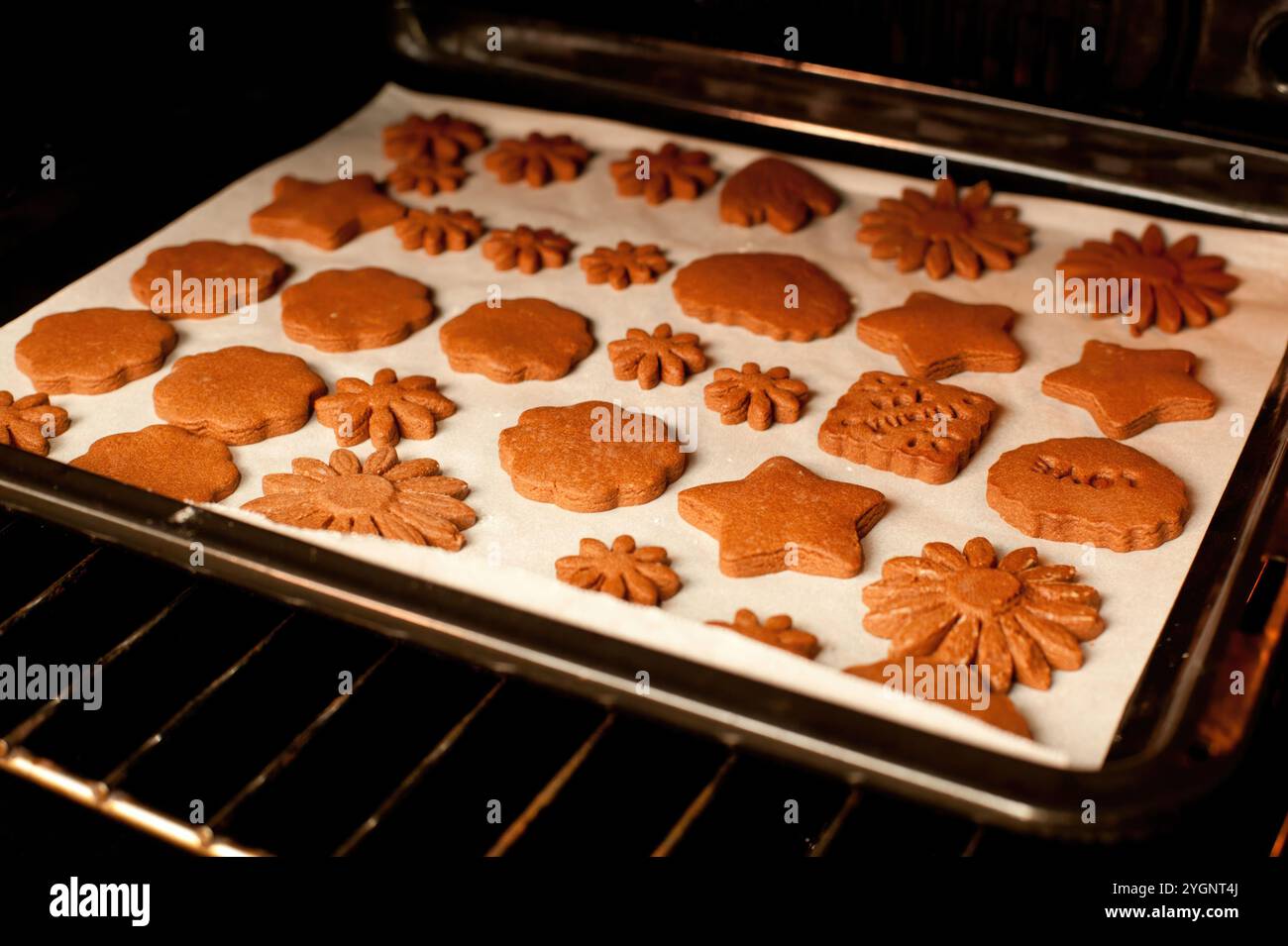 Delicious gingerbread cookies of various shapes and sizes baking on a ...