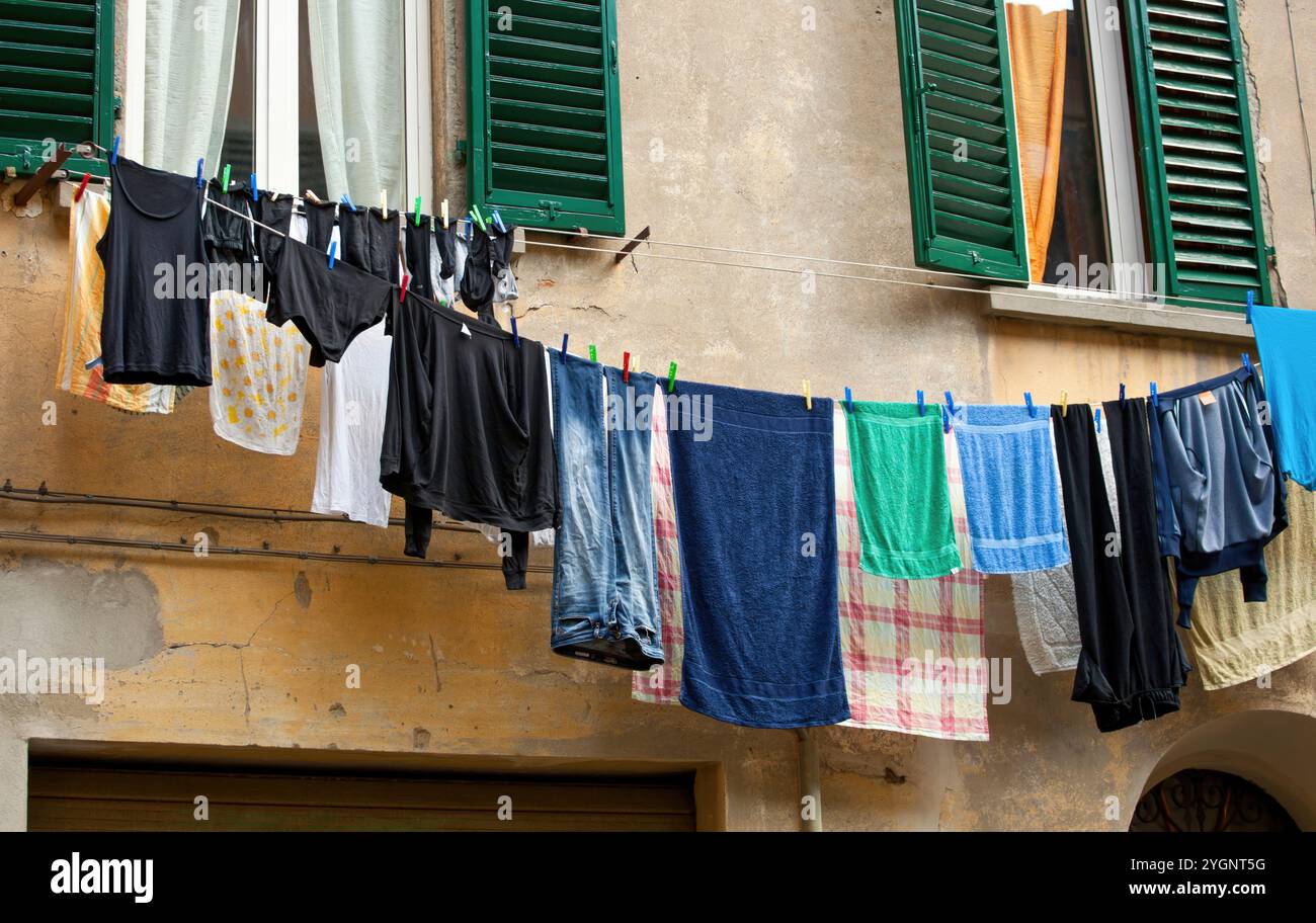 Laundry hanging out to dry on a clothesline strung across an alley with ...