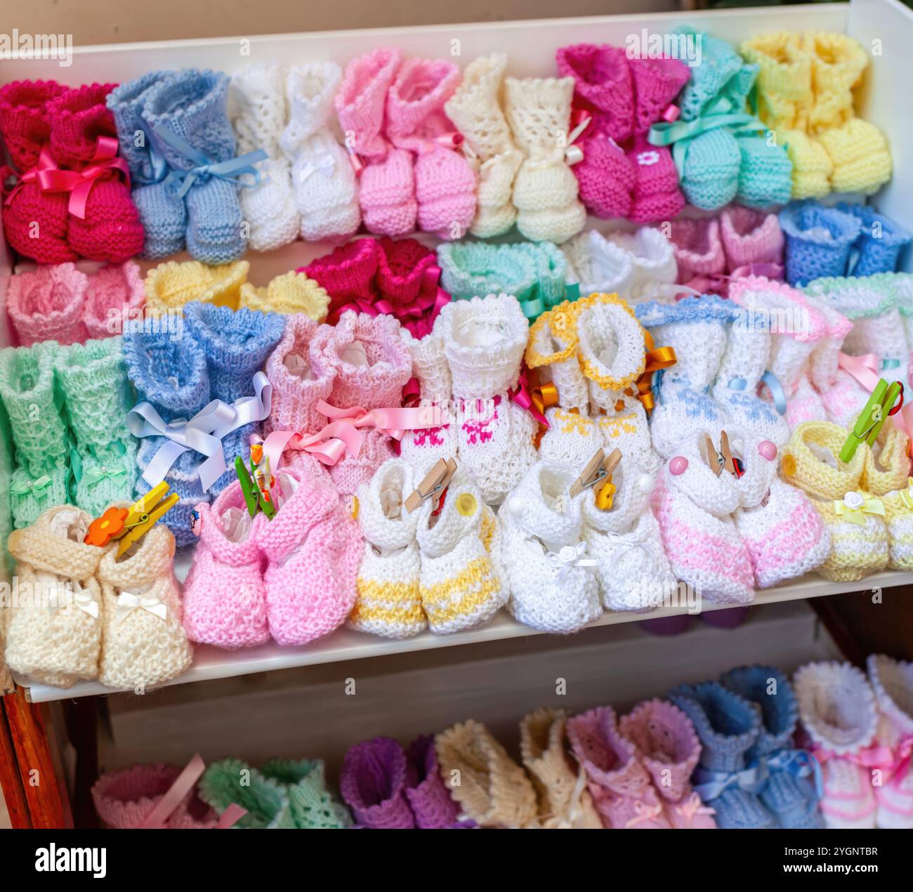 Shelves displaying rows of colorful handmade baby booties, showcasing ...