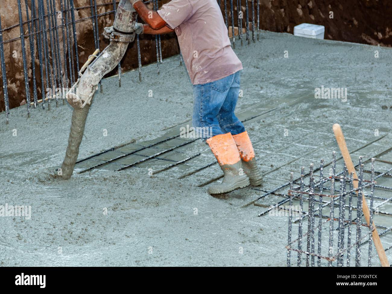 Construction worker pouring concrete slab for new house foundation ...