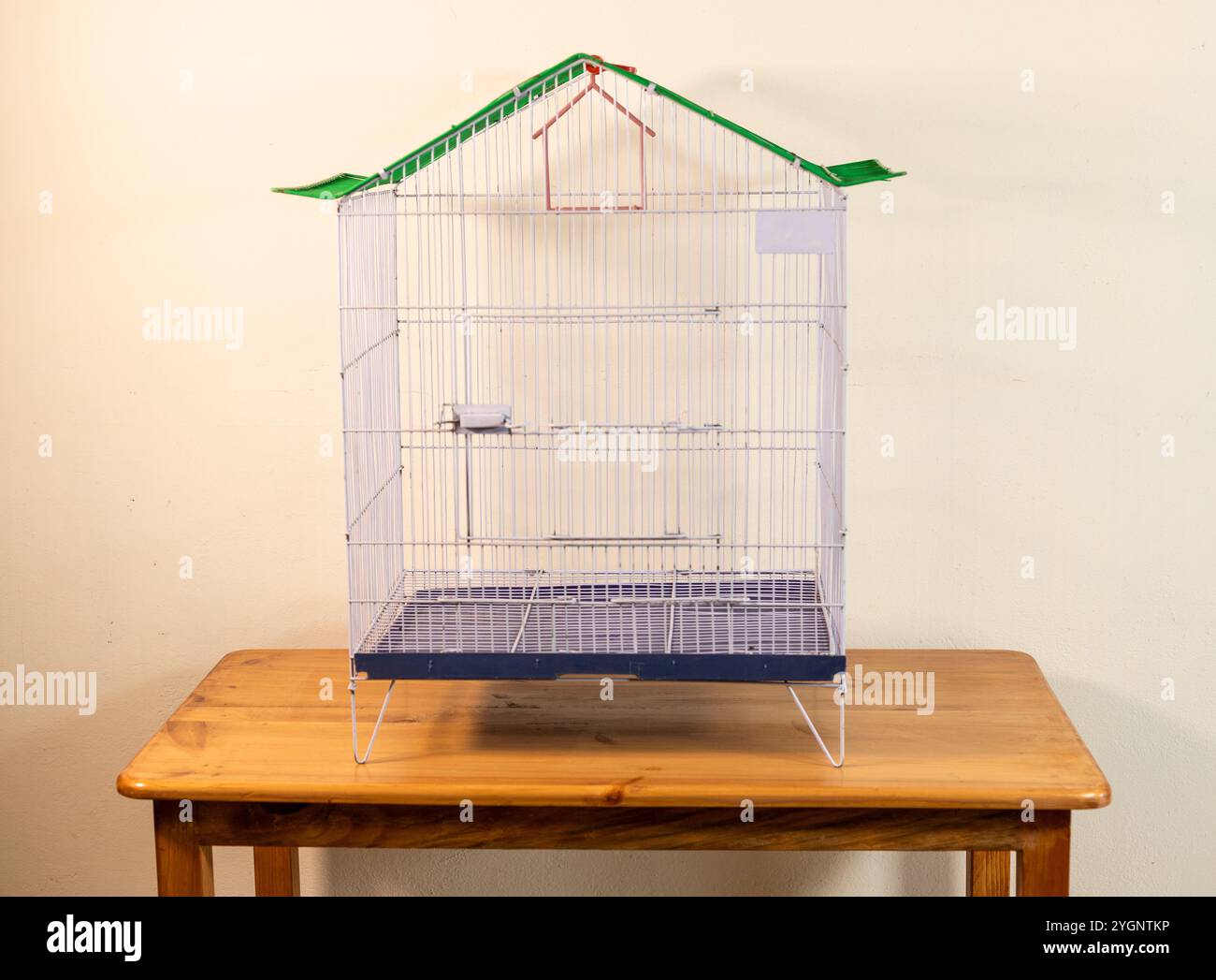 Metal Bird Cage with Green Roof on Wooden Table Stock Photo - Alamy