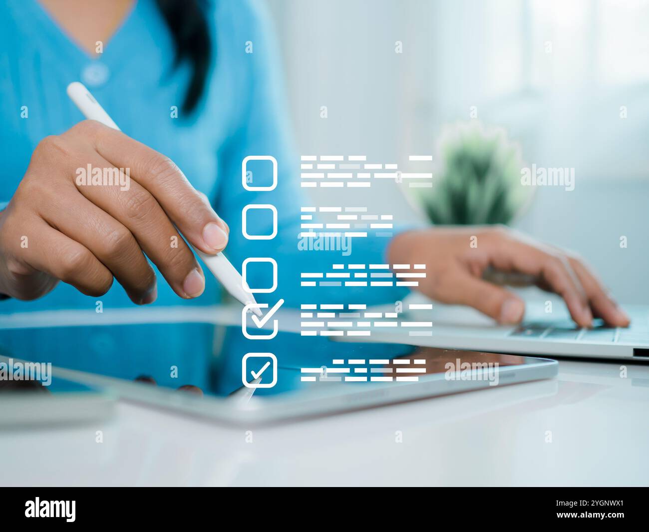 Woman working on laptop and tablet productivity checklist and filling ...