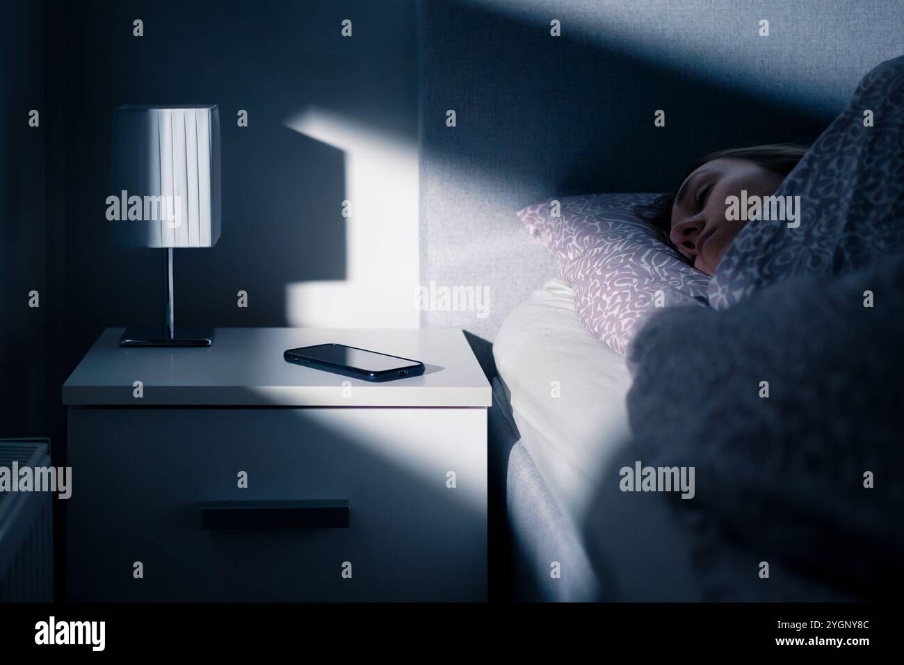 Phone next to bed while sleeping. Mobile on table and nightstand at ...