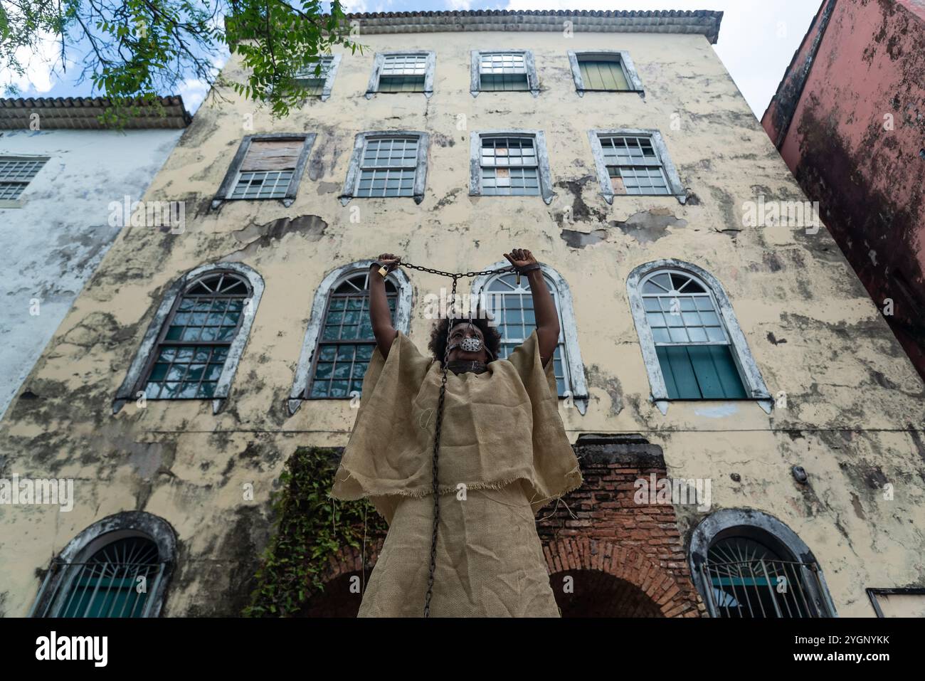 Black woman dressed as a slave, chained and with an iron mask over her ...