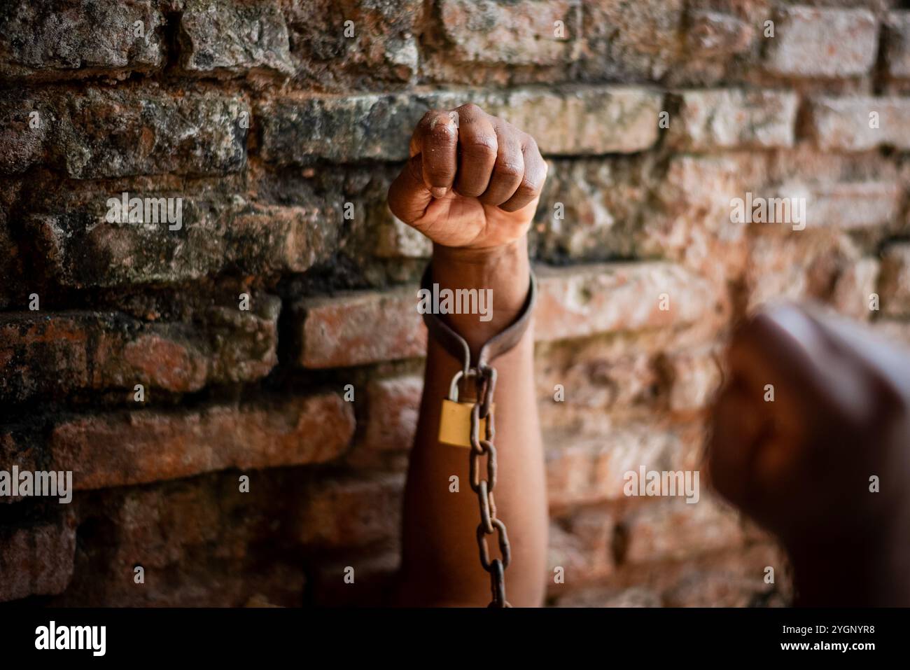 Chained arms of a black woman against a brick wall. Slavery in Brazil. Representing the slave ...