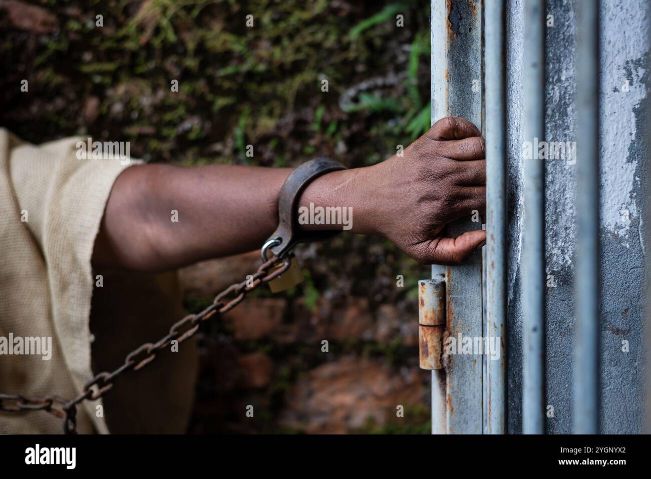 Details of an arm chained against an old brick wall. Slavery in Brazil ...
