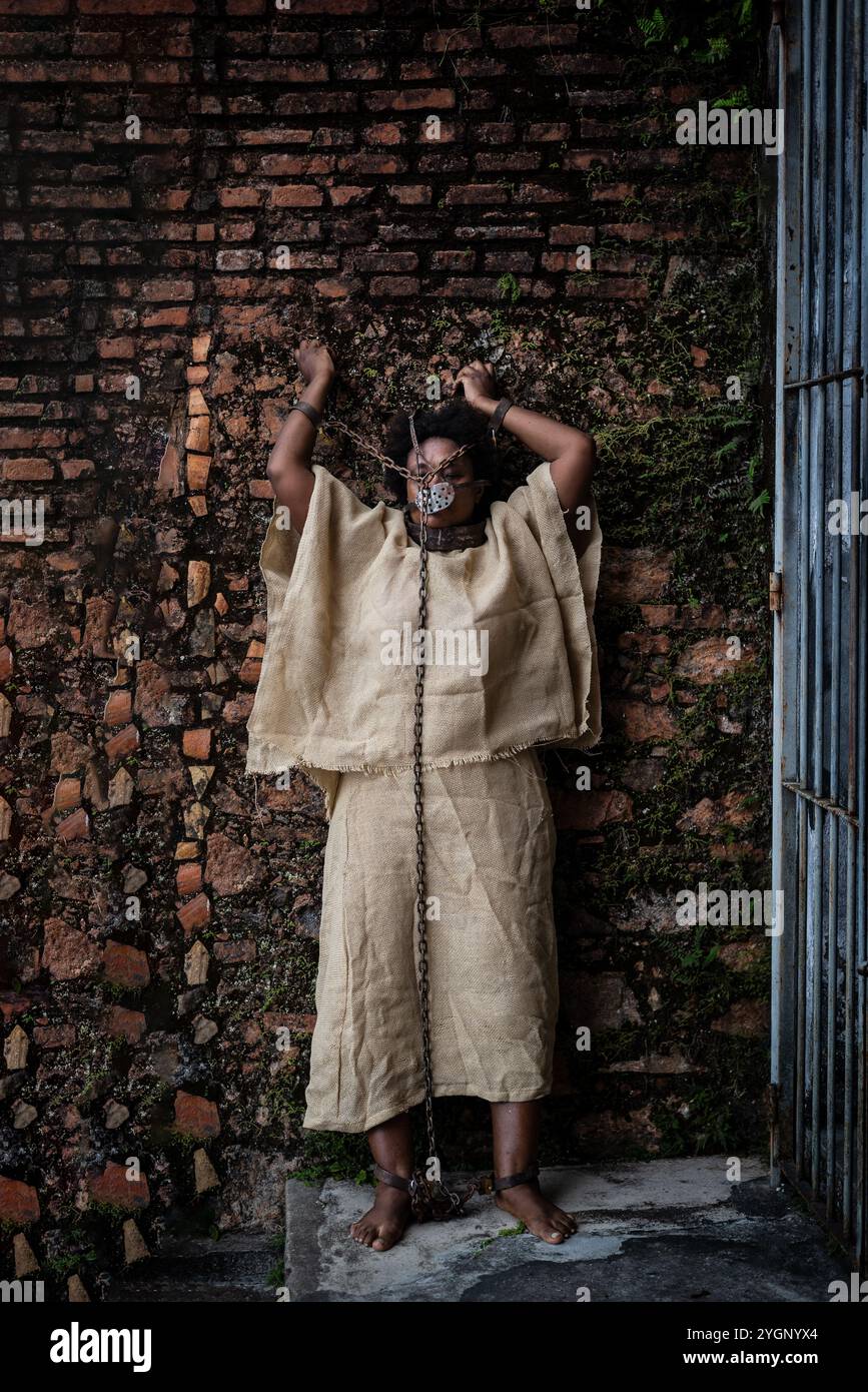 Portrait of a black woman chained with an iron mask on her mouth with ...